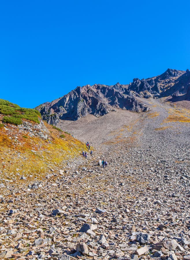 Stone Slope of the Volcano with Walking Tourists. Stock Image - Image ...