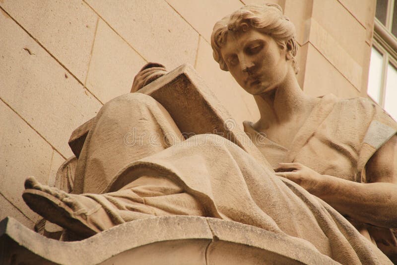 A Stone Statue with a Book on a Ledge on a Building Stock Photo - Image ...