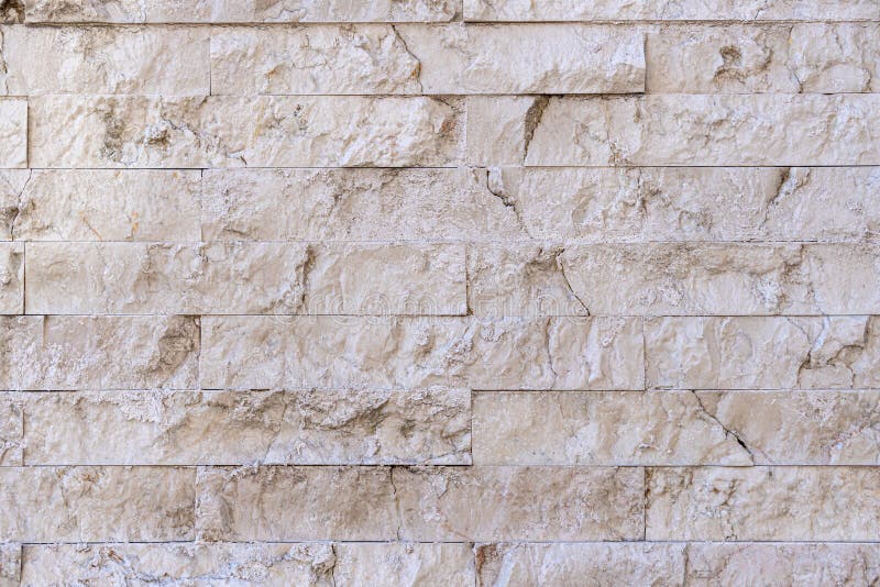Stone Wall Made of Beige Tiles Arranged in a Staggered Pattern. Stock ...