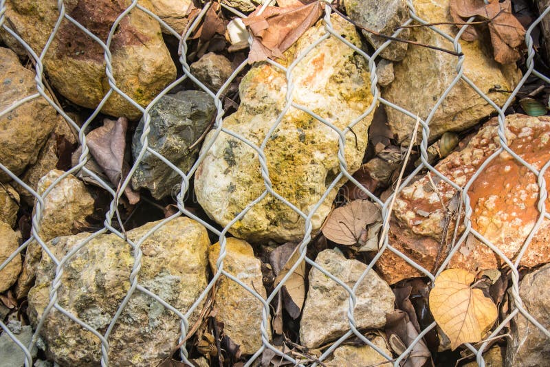 Stone wall in metallic net stock image. Image of construction - 74529151