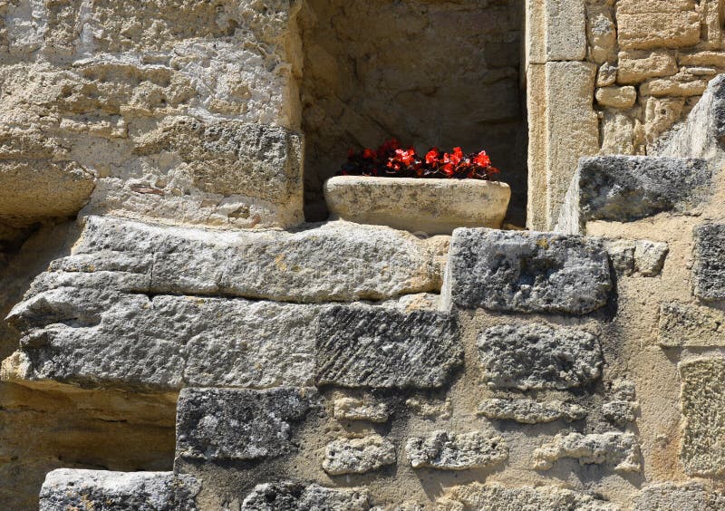 Stone wall - red flowers stock image. Image of flowers - 72691145
