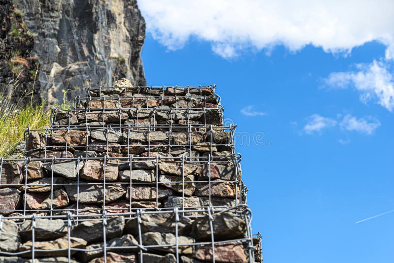 A Stone Wall Standing by the Road, Made of Stones Protected by Metal ...