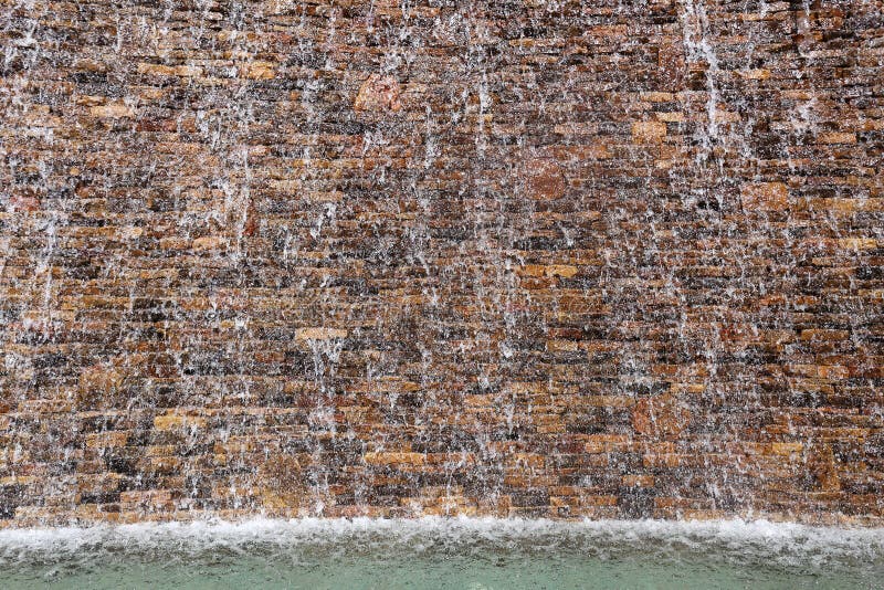 Stone Wall with Water Falling Down it into Fountain Stock Image - Image ...