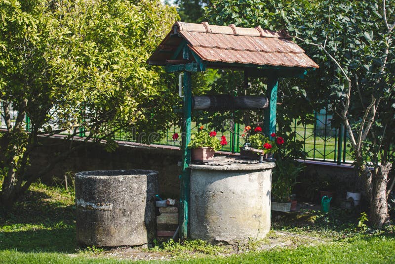 Stone Water Well with Red Flowers in the Garden Stock Image - Image of ...