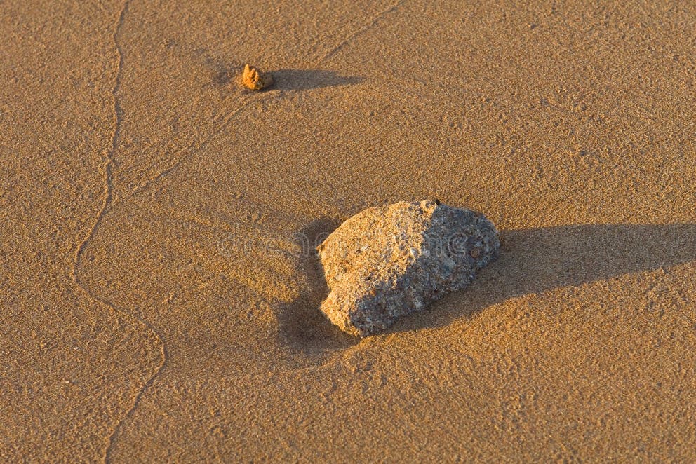 Stone in the Sand and a Wave Stock Photo - Image of texture, sand: 93347064