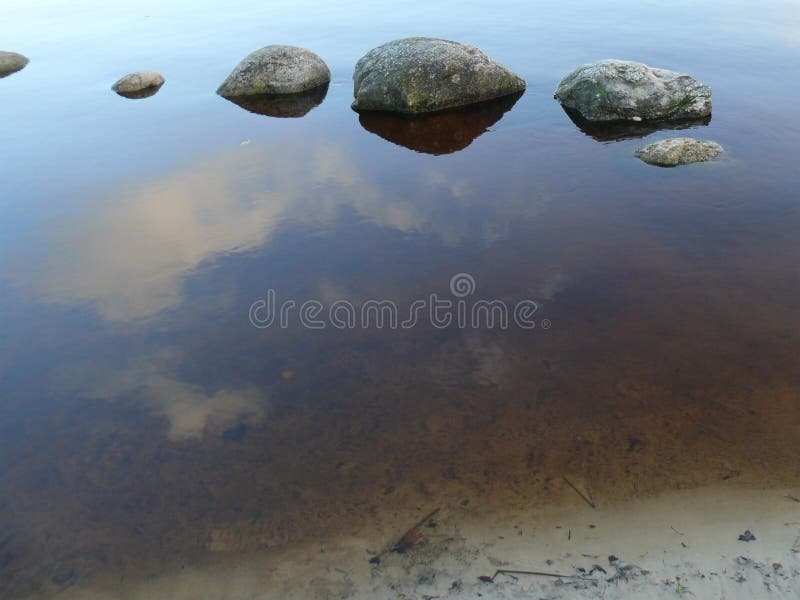 Stones in a lake stock photo. Image of reflected, stones - 149704674