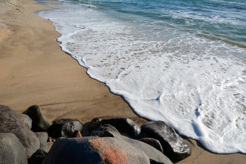 Stones Lie on the Sandy Sea Beach. Foamy Waves Roll in Stock Image ... Stones Lie on the Sandy Sea Beach. Foamy Waves Roll in Stock Image ...