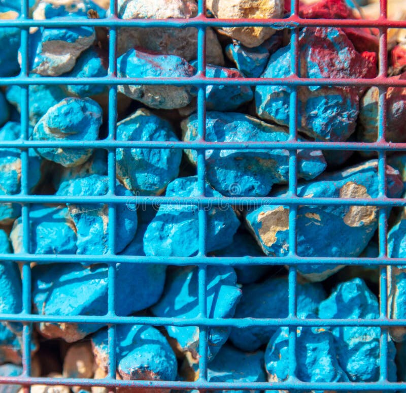 Stones Painted with Blue Paint in a Metal Grid As a Background Stock ...