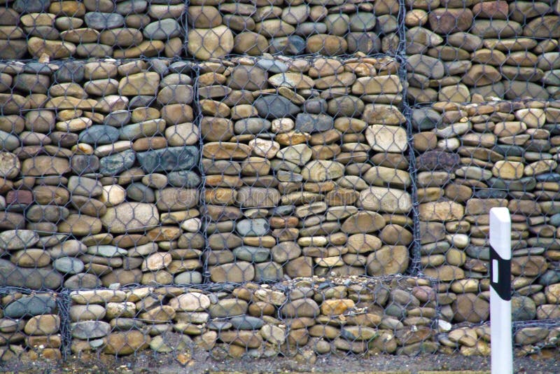 Stones Piled Neatly in Nets Along the Road Stock Image - Image of fence ...