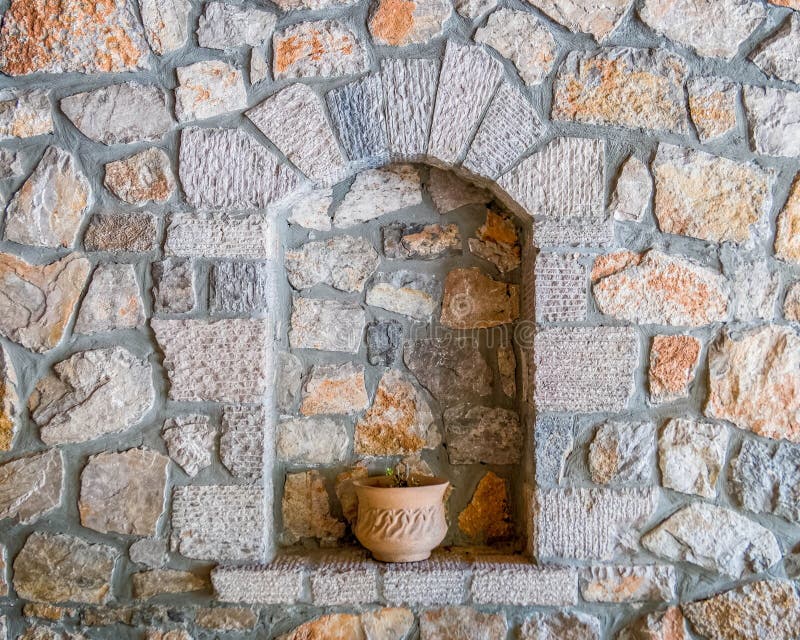 A Stonewall with an Arch Frame Shape Decorative Cavity and Ceramic Pot ...
