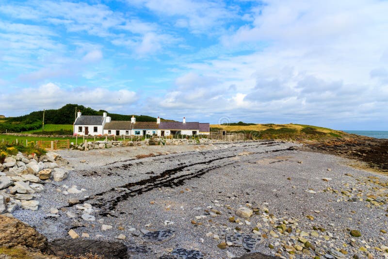 Stony beach at Moelfre stock image. Image of blue, homes - 157212321