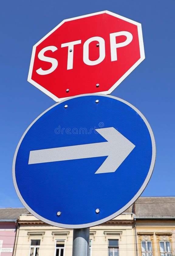 Stop Sign and Arrow Sign at the Road Crossing Stock Image - Image of ...