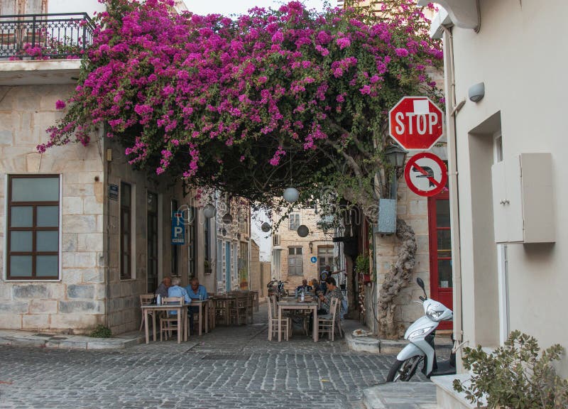 Stop Sign at a Bustling Intersection with People Sitting at a Small ...