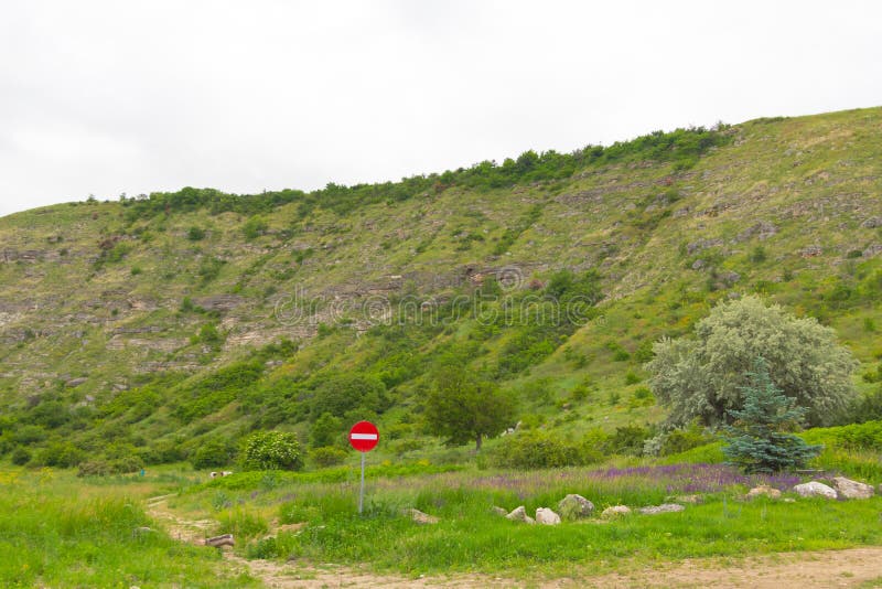 Stop Sign on Landscape Field in Front of a Hill Stock Image - Image of ...