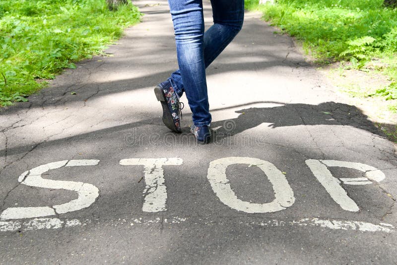Stop Sign Painted on the Road and Female Legs. Stock Photo - Image of ...