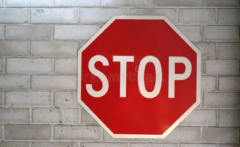 Stop Sign on the Pale Grey Brick Wall Stock Image - Image of ...