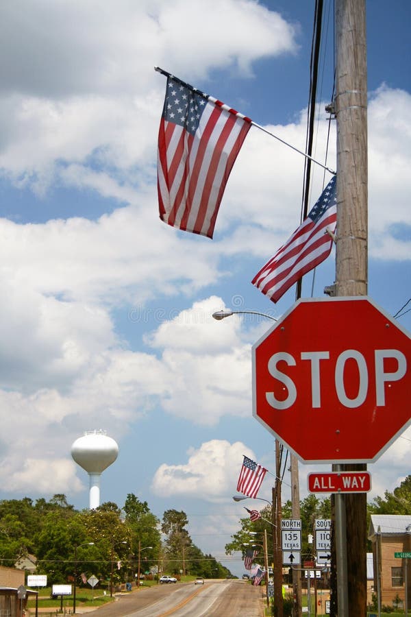 Stop Sign in Small Rural Town with American Flags and Water Tower ...
