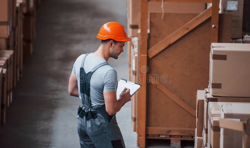 Storage Worker in Uniform and Notepad in Hands Checks Production Stock ...