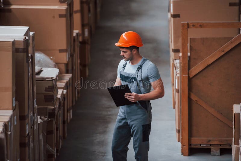 Storage Worker in Uniform and Notepad in Hands Checks Production Stock ...