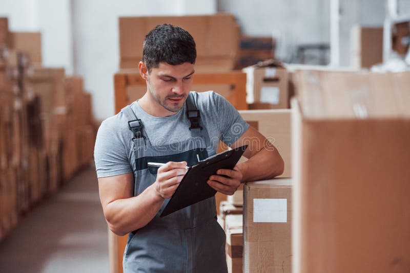 Storage Worker in Uniform and Notepad in Hands Checks Production Stock ...