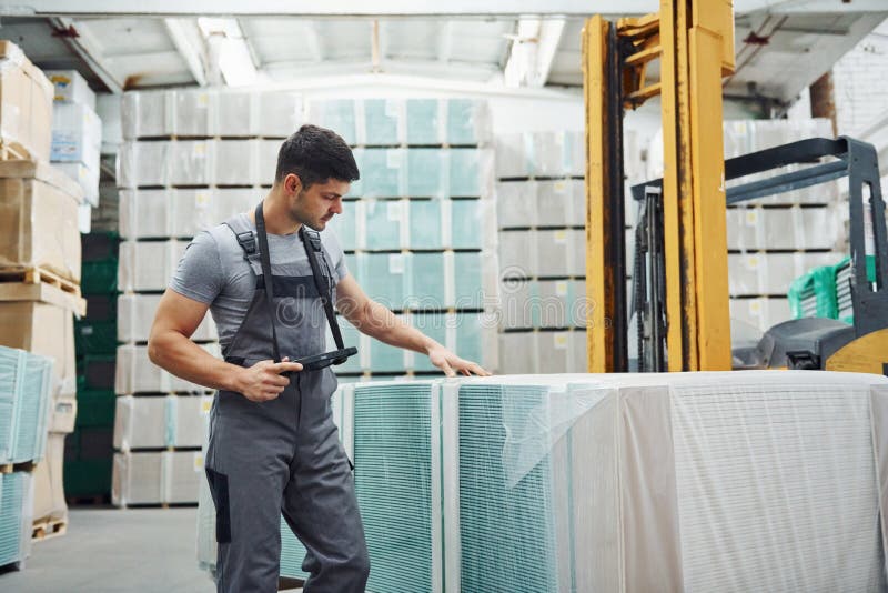 Storage Worker in Uniform and Tablet in Hands Checks Production Stock ...