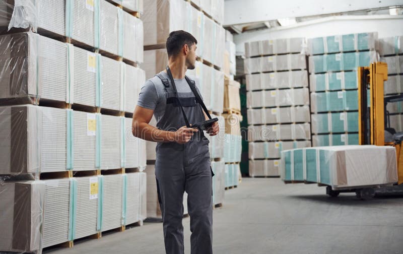 Storage Worker in Uniform and Tablet in Hands Checks Production Stock ...