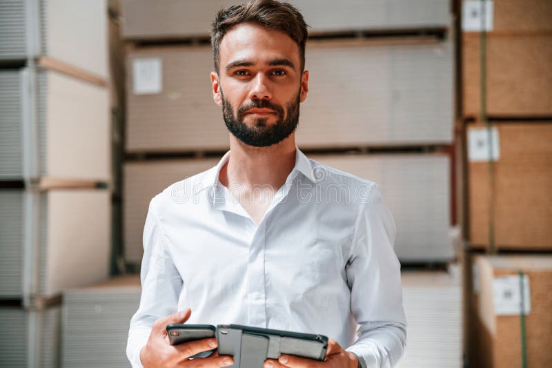 Storage Worker is in the Warehouse with Bunch of Products Stock Photo ...