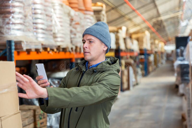 Store Worker Scans Qr Code on Boxes Using Smartphone in Warehouse Shop ...