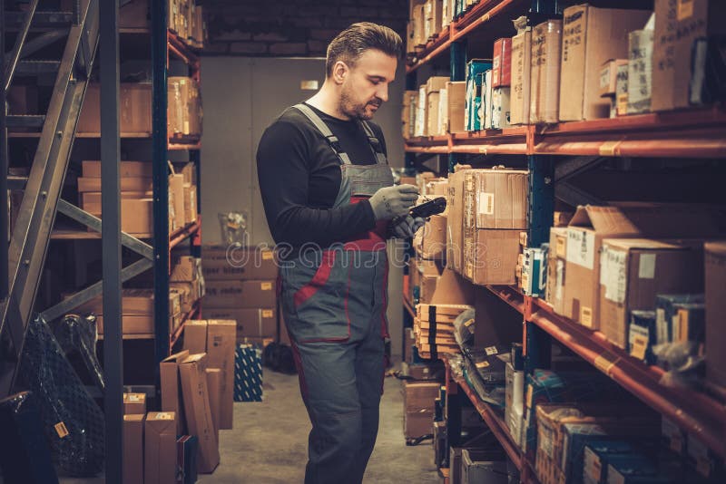 Storekeeper with Handheld Barcode Scanner Working in a Warehouse Stock ...