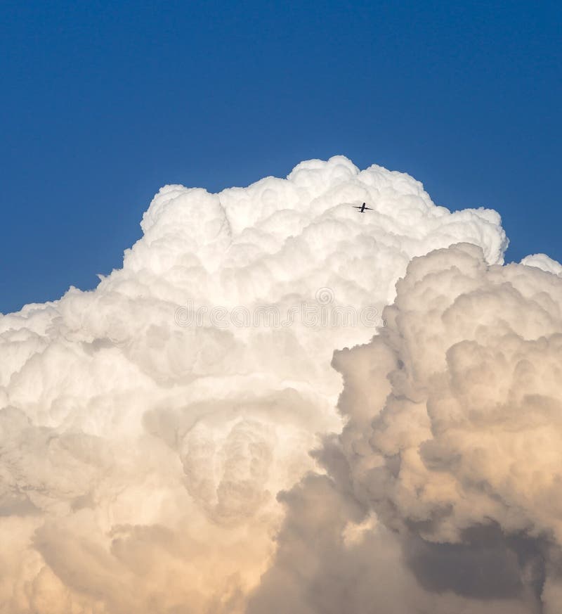Storm Clouds and a Distant Airplane Stock Image - Image of light, blue ...