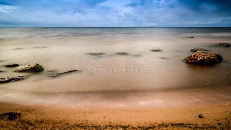 Storm Clouds Forming Over Clear Sea Beach with Rocks and Clear S Stock ...