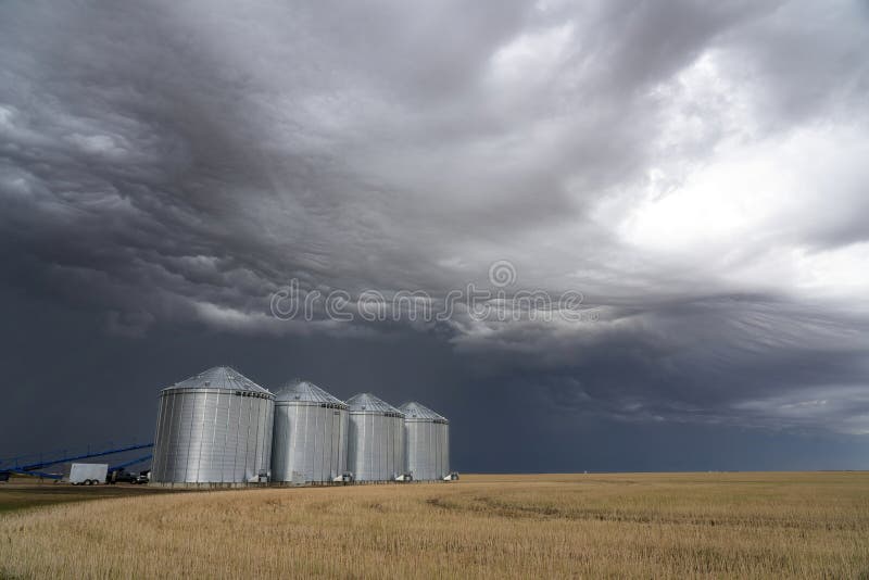 Storm Clouds Gathering Over Grain Silos in a Field Stock Image - Image ...