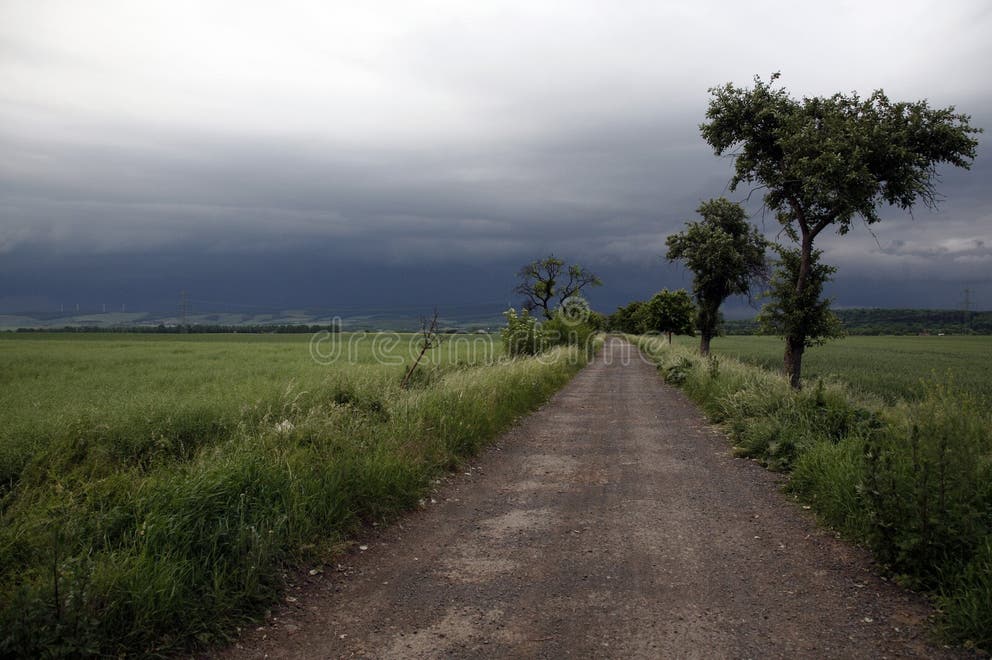 Storm Clouds Over Country Road Stock Photo - Image of moody, inclement ...