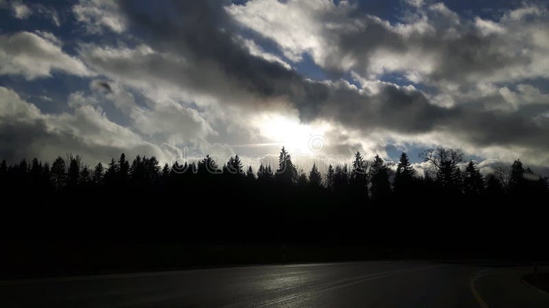 Storm Clouds at Sunset with Forest Silhouettes on the Road Stock Photo ...