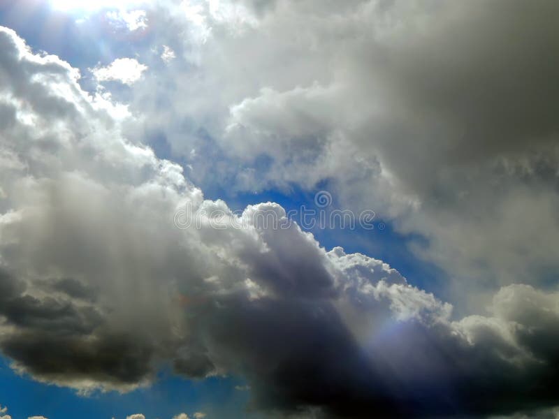 Stormy Clouds in the Blue Sky with the Dawn of the Sun Rays Stock Photo ...