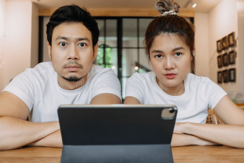 Straight Faces of Asian Man and Woman Working with Computer Tablet in Cafe Stock Image - Image ...