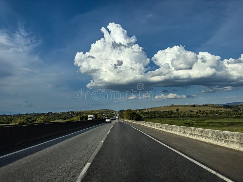 A Straight Highway with a Large Cloud in the Background. Stock Photo ...