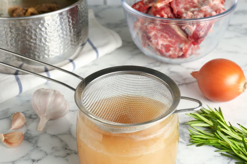 Straining Delicious Broth through Sieve on White Marble Table, Closeup ...