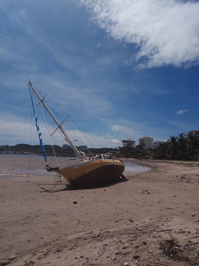 Stranded sailboat on beach stock image. Image of wave - 230144571