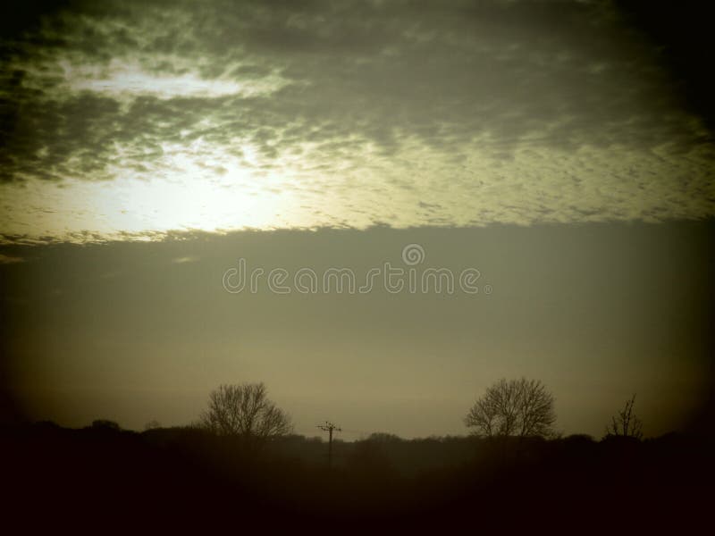 Strangely Lit Clouds Over a Misty Landscape of Distant Oak Trees Stock ...