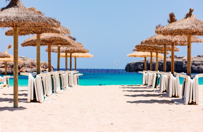 Straw Parasols and Beds on the Sandy Beach Stock Photo - Image of ...