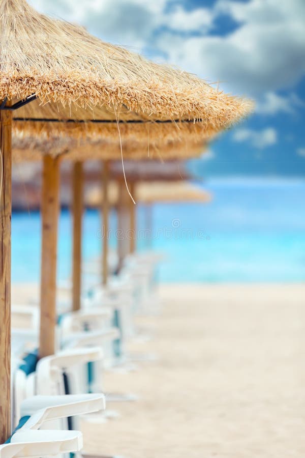 Straw Parasols and Beds on the Sandy Beach. Stock Image - Image of ...