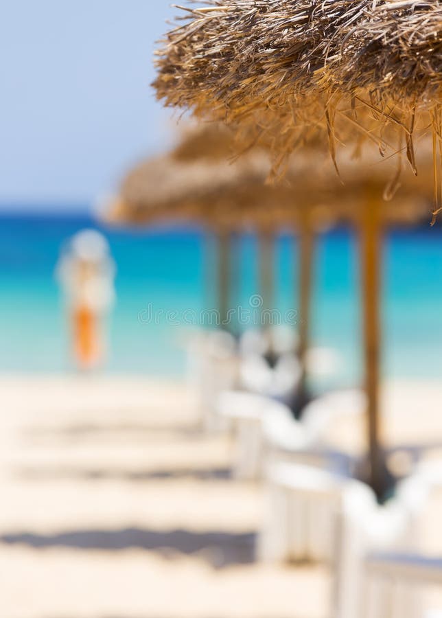 Straw Parasols and Beds on the Sandy Beach. Stock Photo - Image of ...