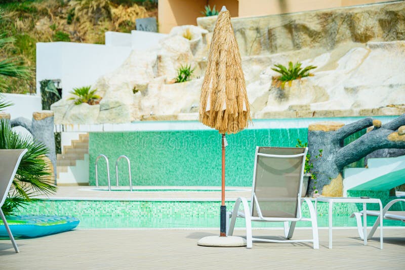 Straw Umbrella and Sunbeds by the Pool. Summer Vacation Resort Stock ...
