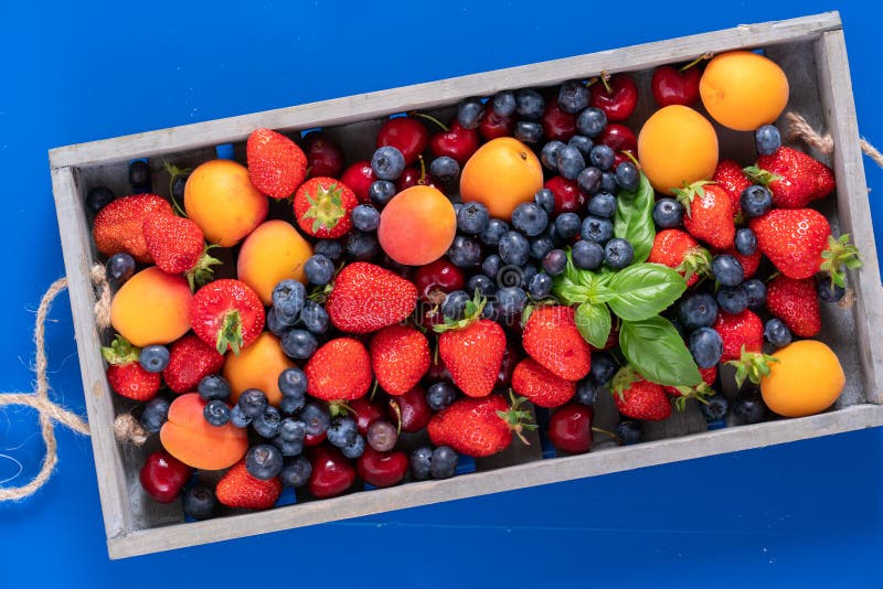 Strawberries, Blueberries, Cherries and Peaches in a Wooden Box Stock ...
