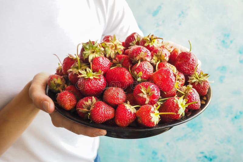 Strawberries on a Plate in His Hands. Stock Image - Image of green ...