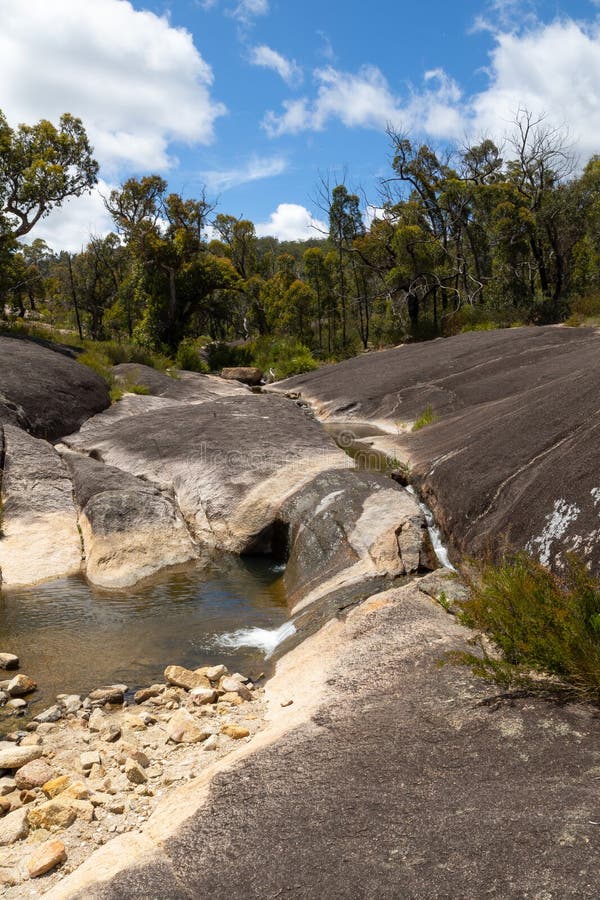 A Stream Flowing Over a Granite Rock Formation with Trees, Sky and ...