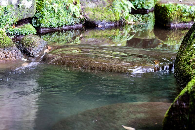 Stream flows over a rock stock image. Image of environment - 121497105
