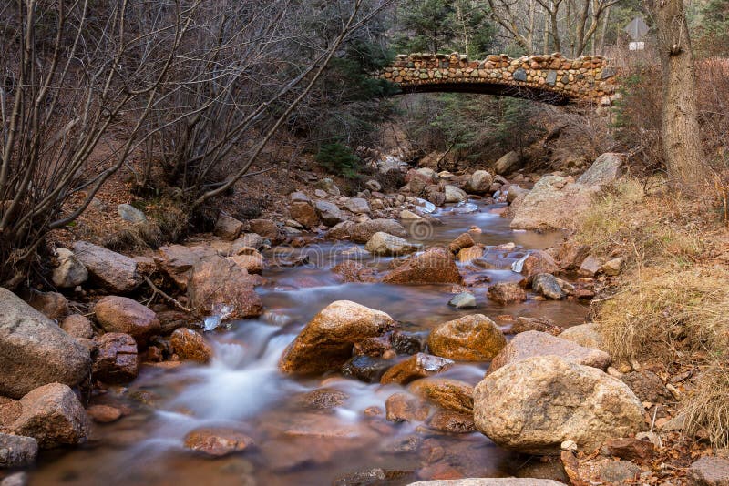 Stream Flows Under an Old Stone Bridge and Over Large Rocks. Stock ...