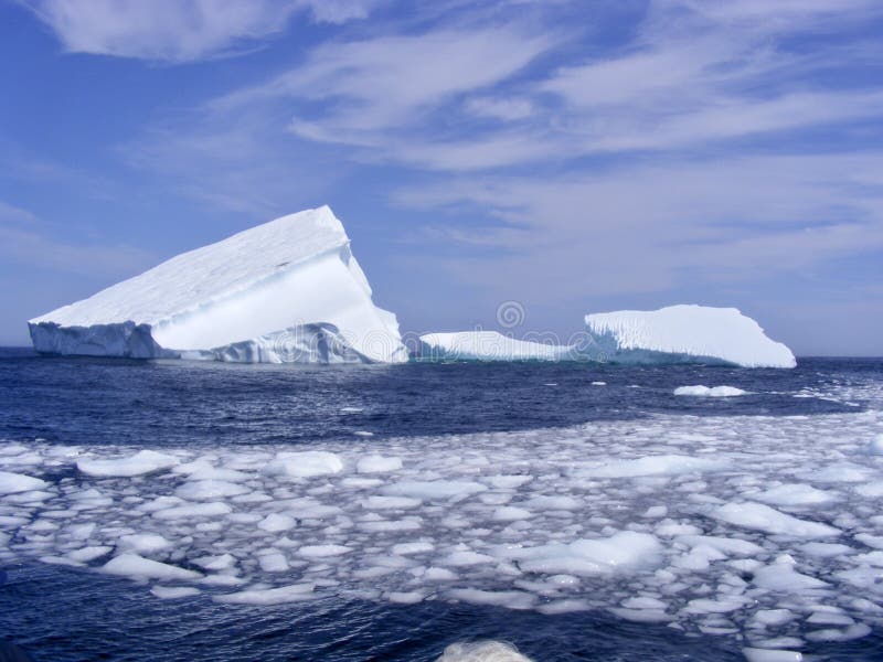 Stream of Ice Chunks Passing in Front of Two Large Icebergs Stock Photo ...